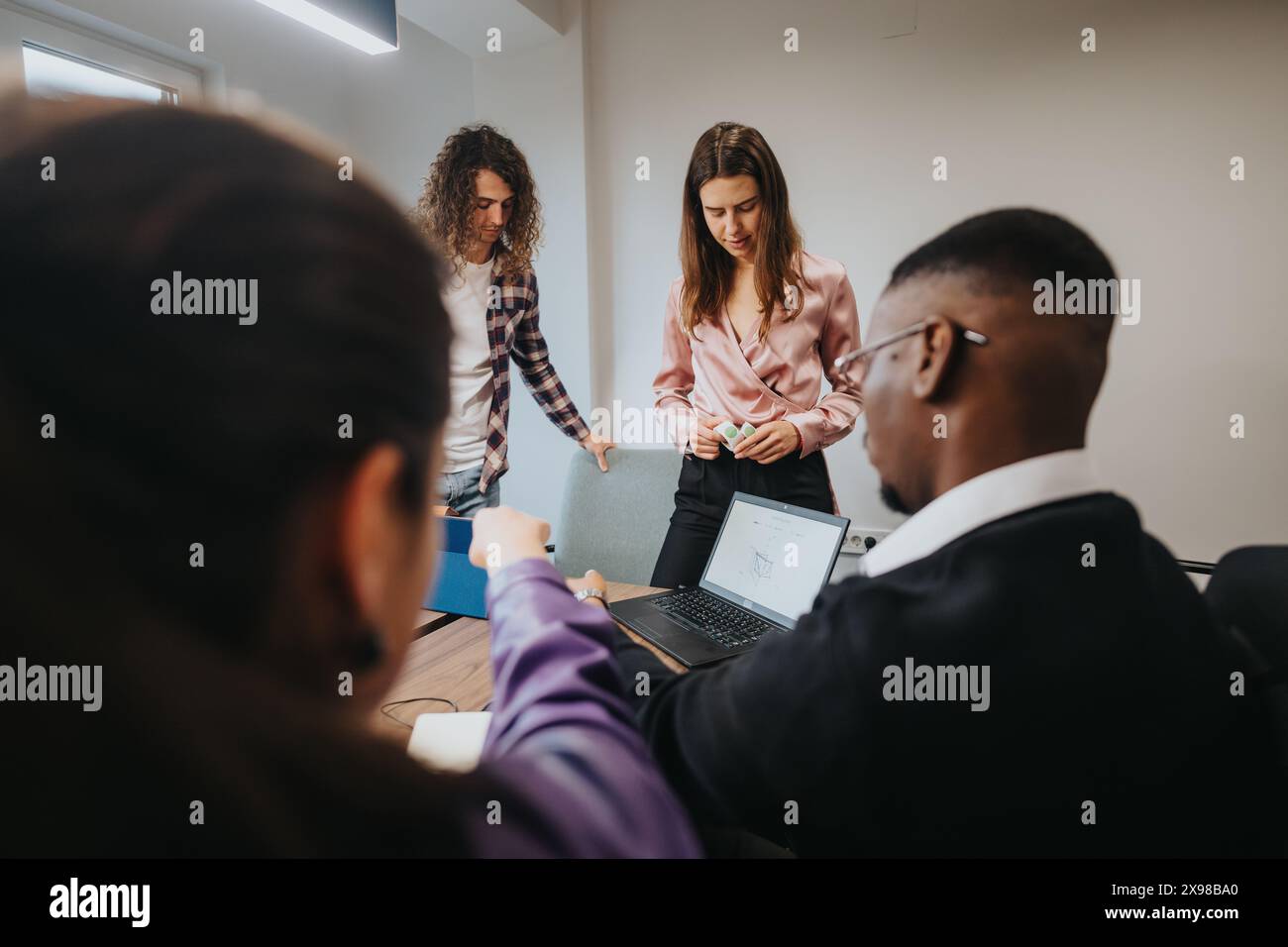 Diverse team collaborates in a modern office setting, engaging in ...