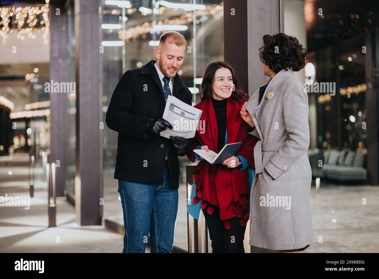 Three people engaged in a friendly discussion with documents, outside ...