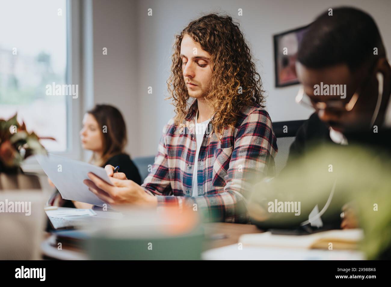 Multicultural team working together in a startup office: young ...