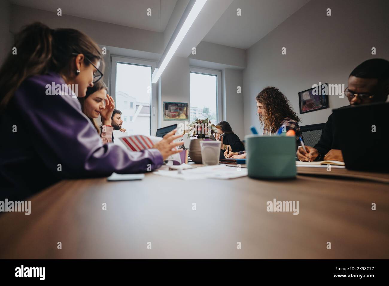 Multicultural team collaborates on a project in a modern office Stock ...