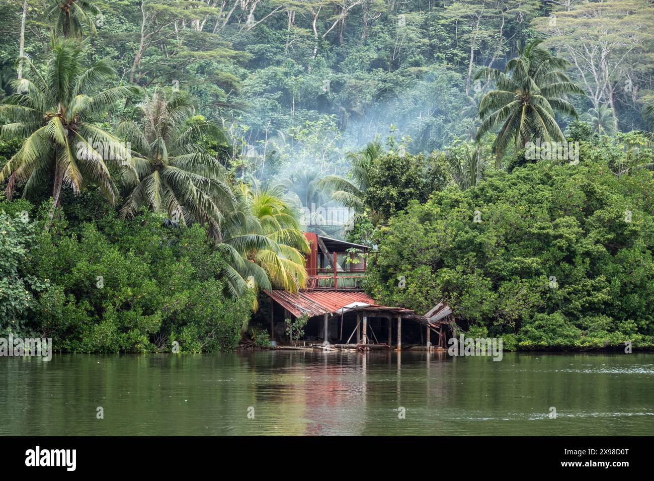 Mysterious abandonned shack in luxuriant tropical forest with smoke ...