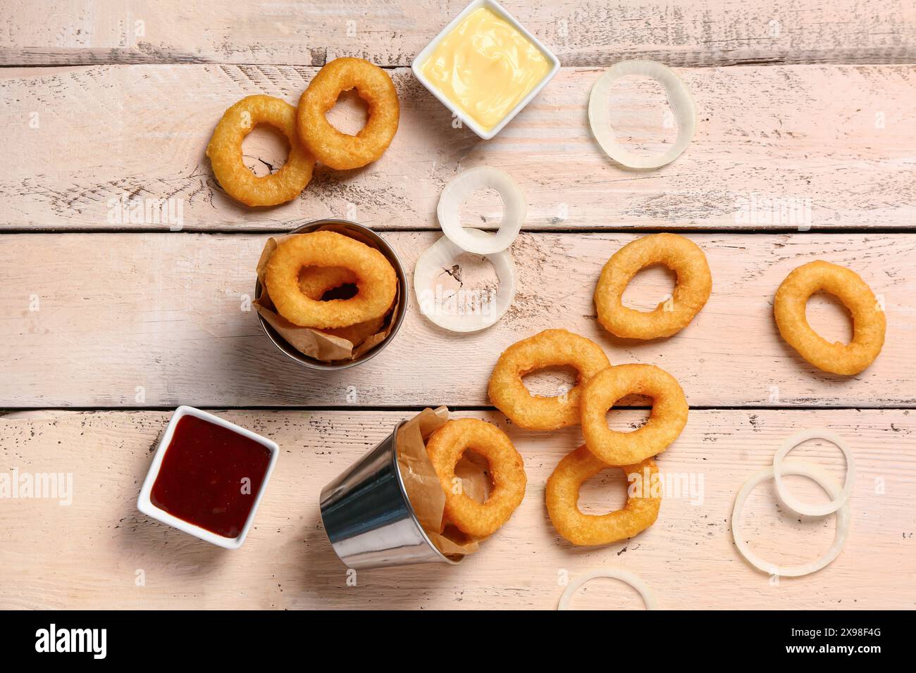 Metal buckets with fried breaded onion rings and different sauces on ...