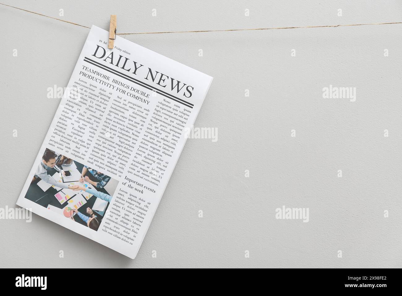 Newspaper hanging on rope against white background Stock Photo - Alamy