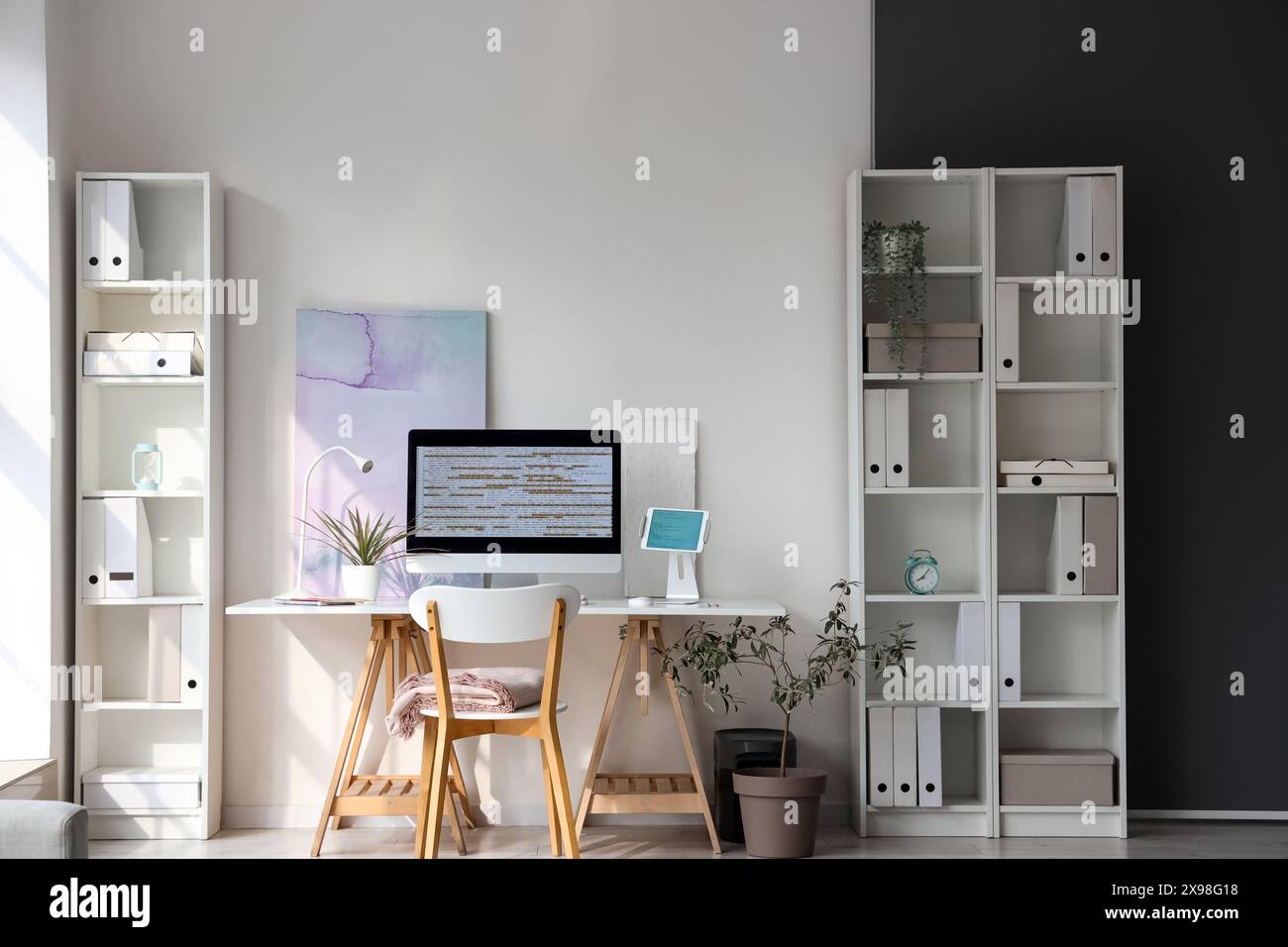 Interior of stylish office with programmer's workplace and shelf units ...