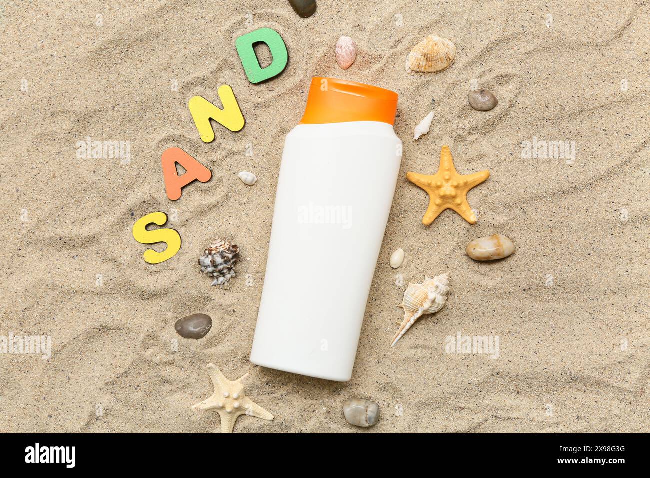 Word SAND, bottle of sunscreen cream and seashells on sand background ...