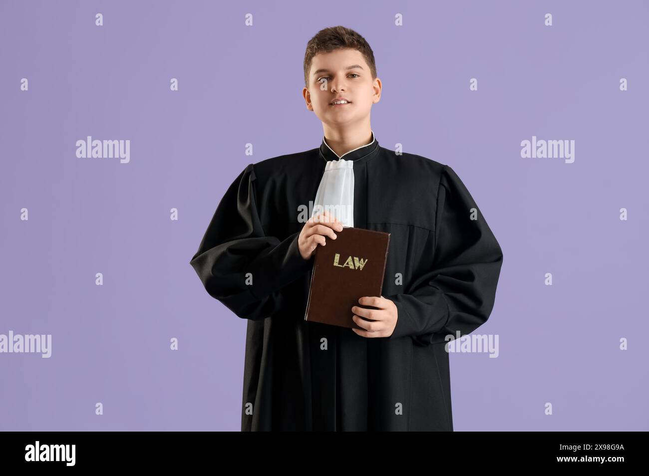 Teenage judge with law book on lilac background Stock Photo - Alamy