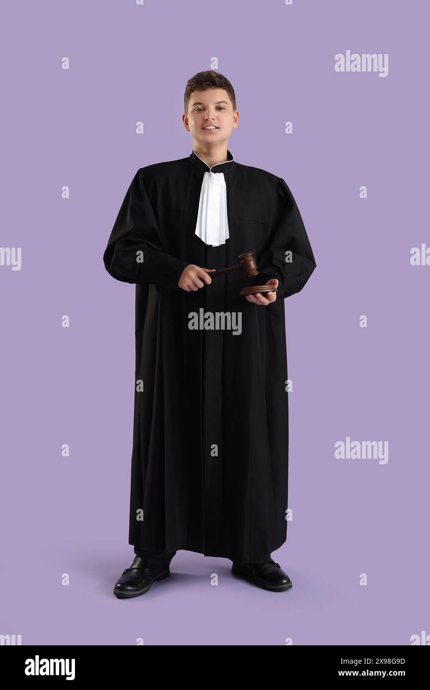 Teenage judge with gavel on lilac background Stock Photo - Alamy