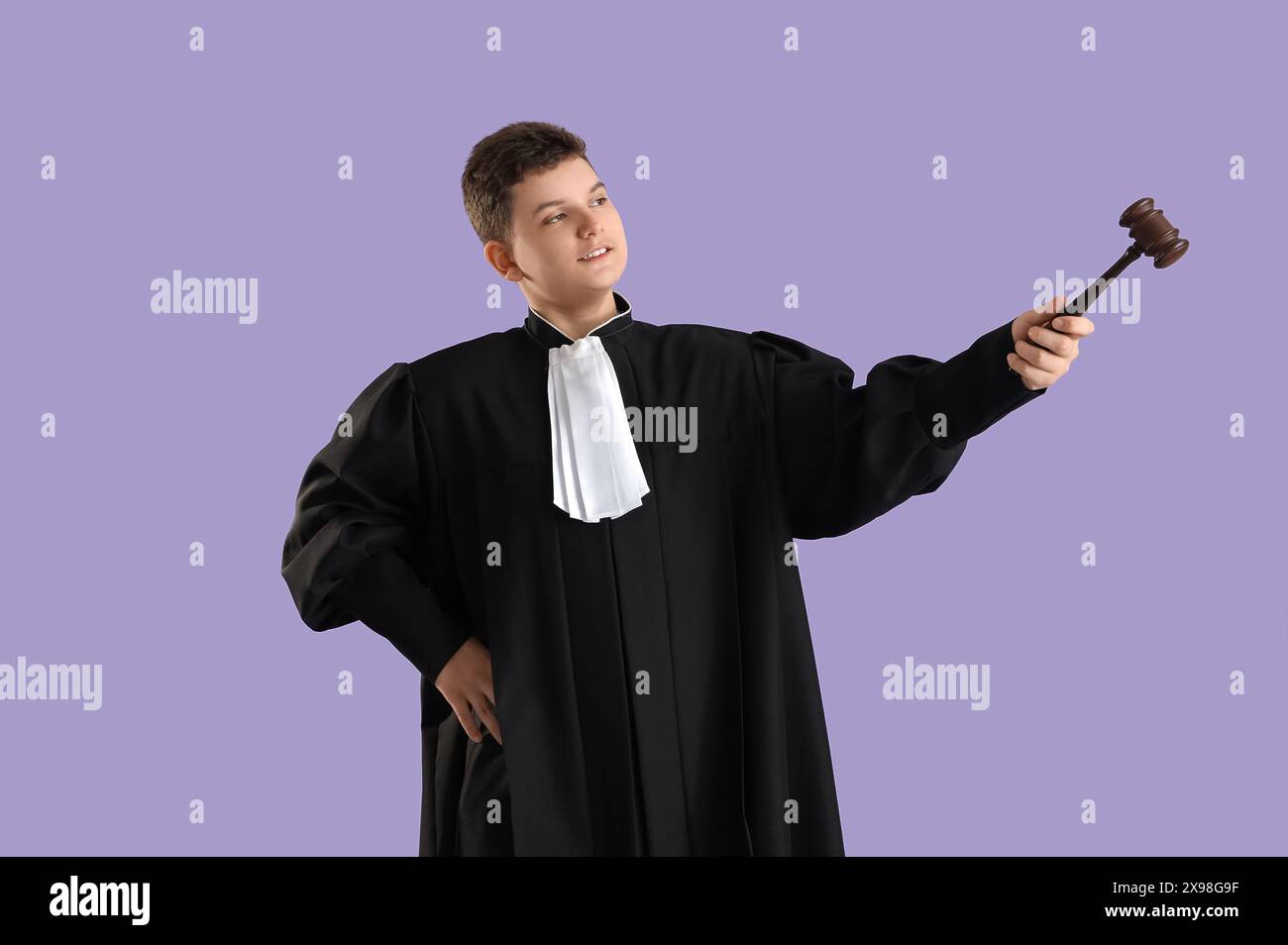 Teenage judge with gavel on lilac background Stock Photo - Alamy