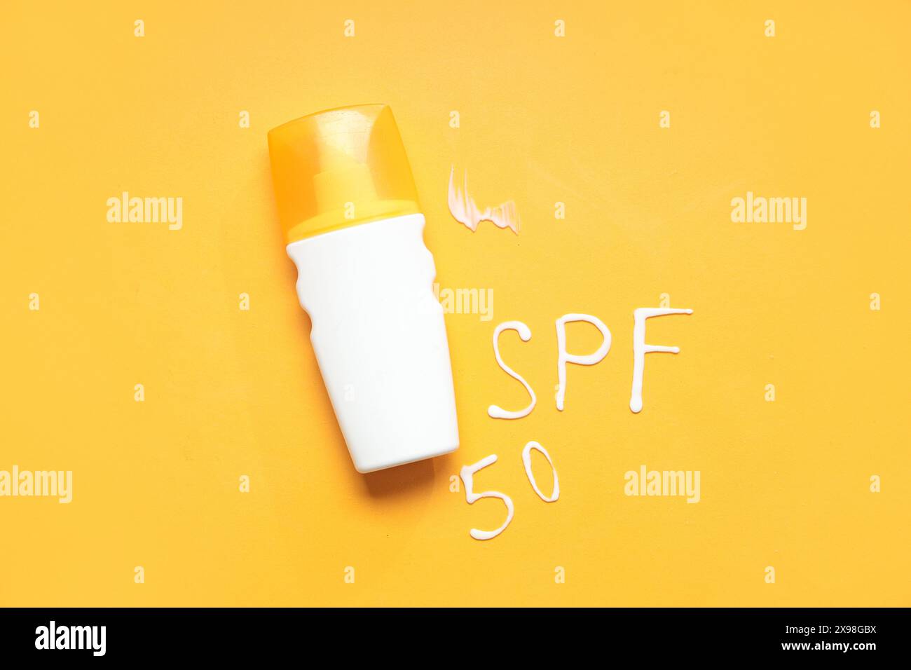 Bottle of sunscreen and text SPF 50 written with cream on color ...