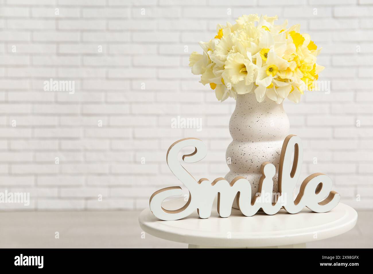 Word SMILE and vase with beautiful narcissus in room Stock Photo - Alamy