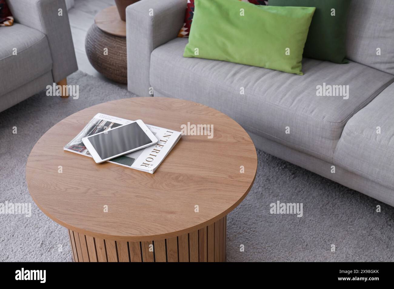 Tablet computer with magazine on table in living room Stock Photo - Alamy