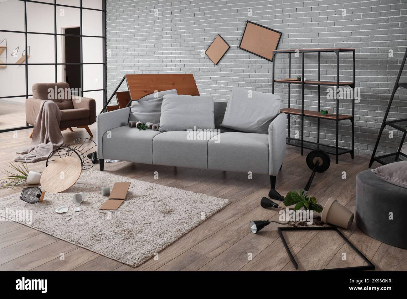 Interior of messy living room with sofa, armchair and shelf units Stock ...
