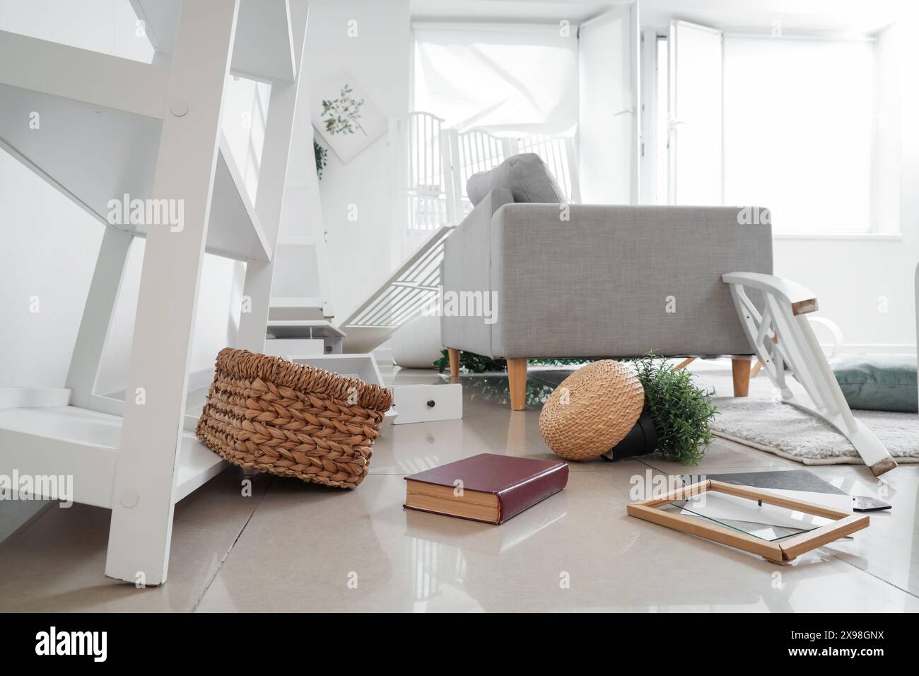Overturned things on floor in messy living room Stock Photo - Alamy