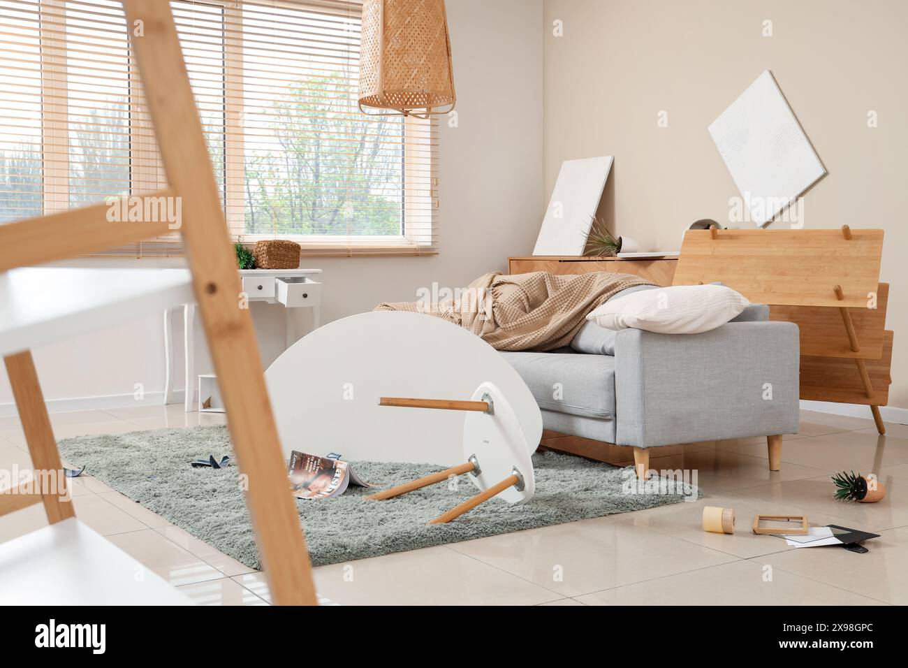 Interior of messy living room with sofa, tables and shelf unit Stock ...