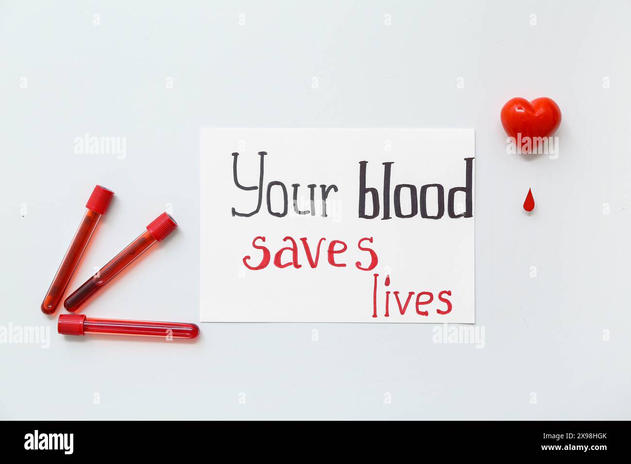 Paper sheet with text YOUR BLOOD SAVES LIVES, heart and blood samples ...