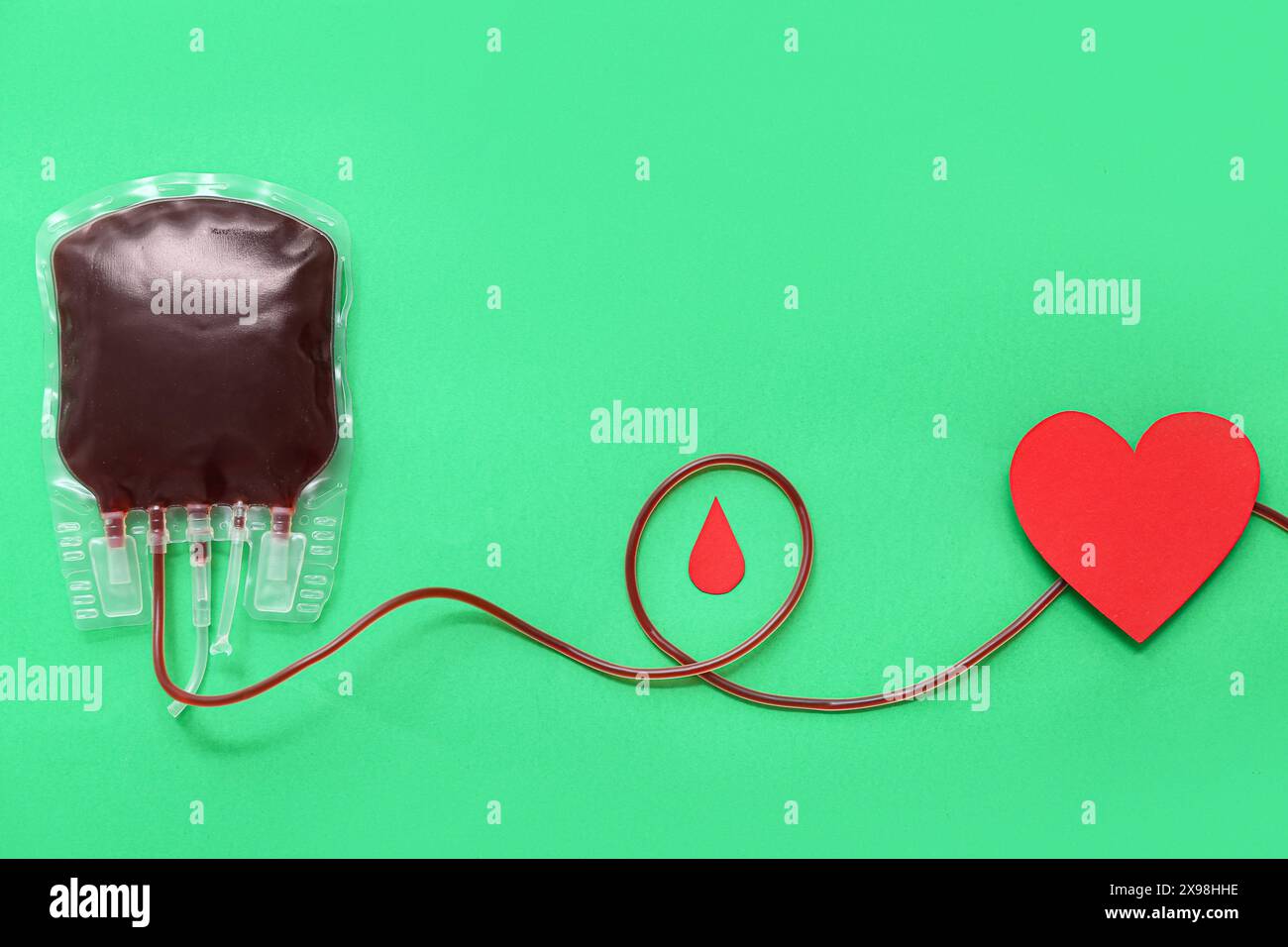Blood pack with paper heart on green background. World Blood Donor Day ...