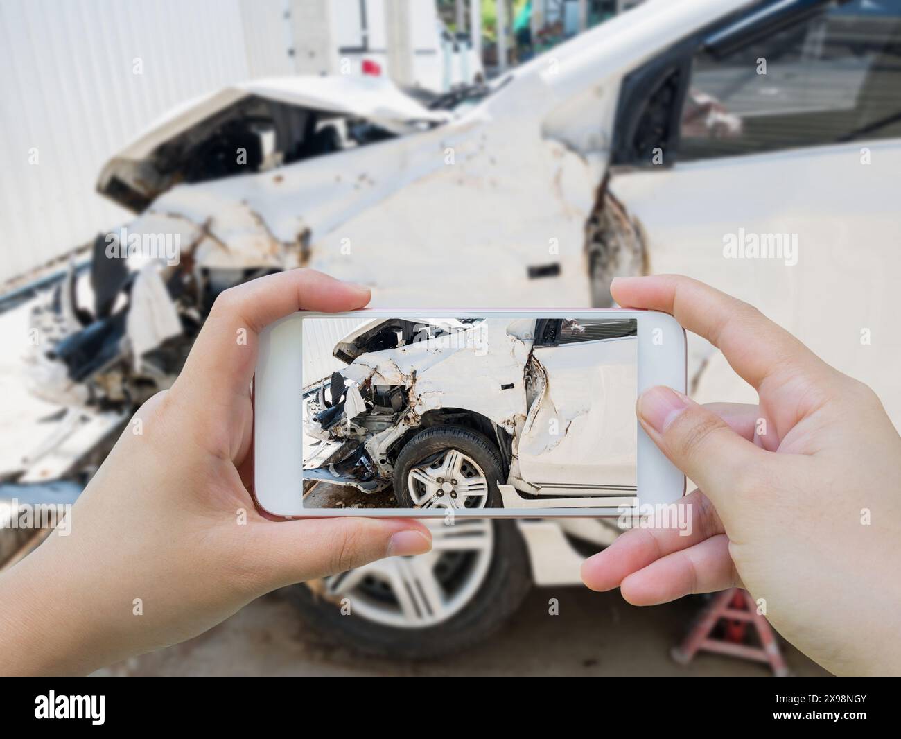 Female using mobile smart phone taking photo of the car crash accident ...
