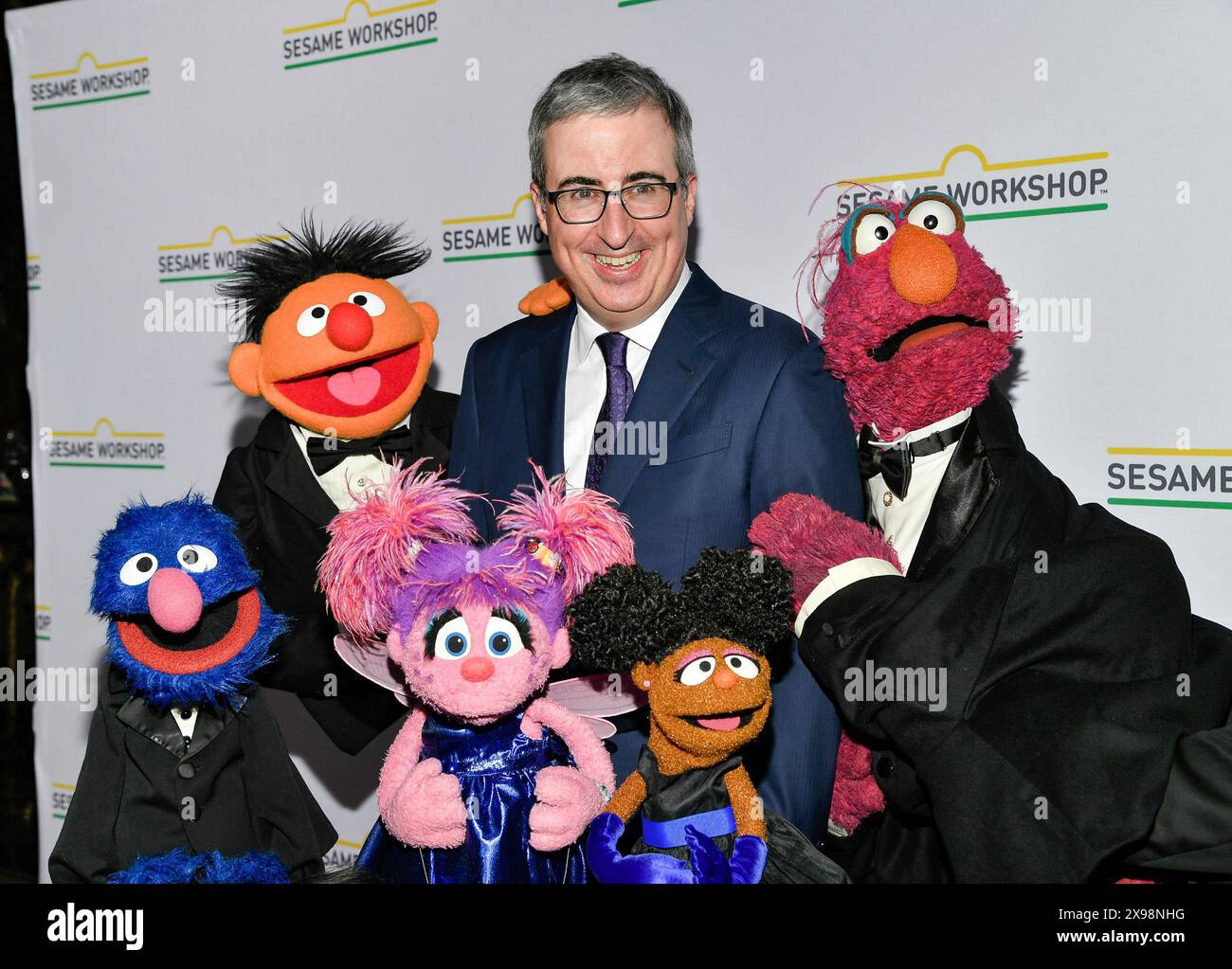 John Oliver, center, poses with Muppet characters at the Sesame ...