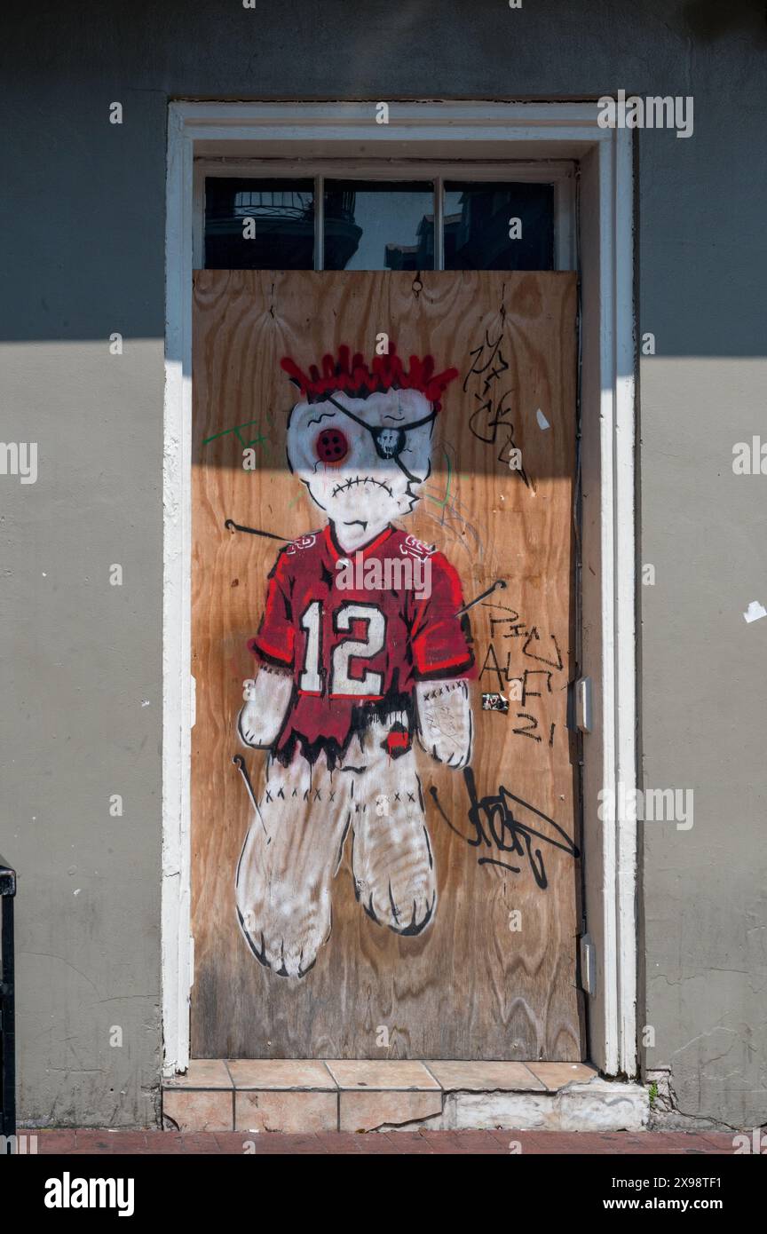 Cartoon voodoo doll graffiti on a boarded-up door after Hurricane Ida ...