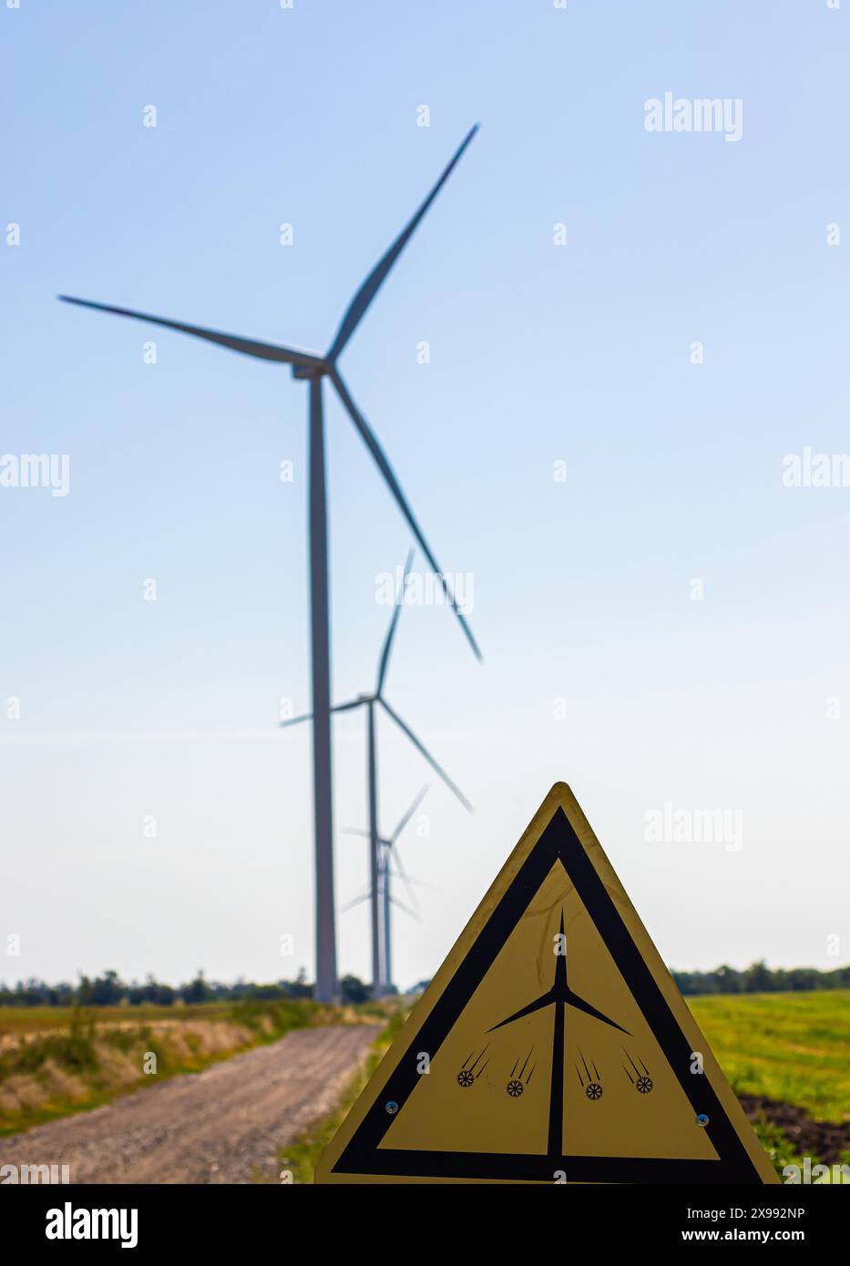 Wind Turbines with a caution sign warning of the dangers of approaching ...