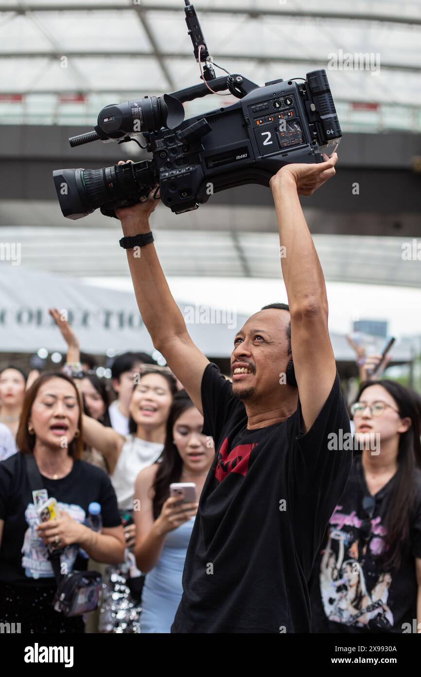 Professional camera crew member lift up the heavy camera over his head ...