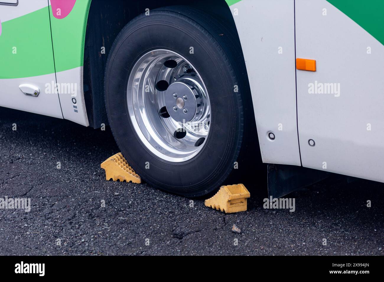 Close up of a wheel stopper for a passenger bus parked on an asphalt ...