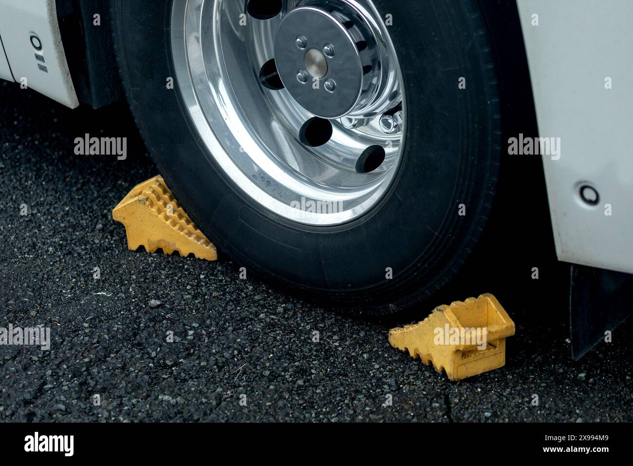 Close up of a wheel stopper for a passenger bus parked on an asphalt ...