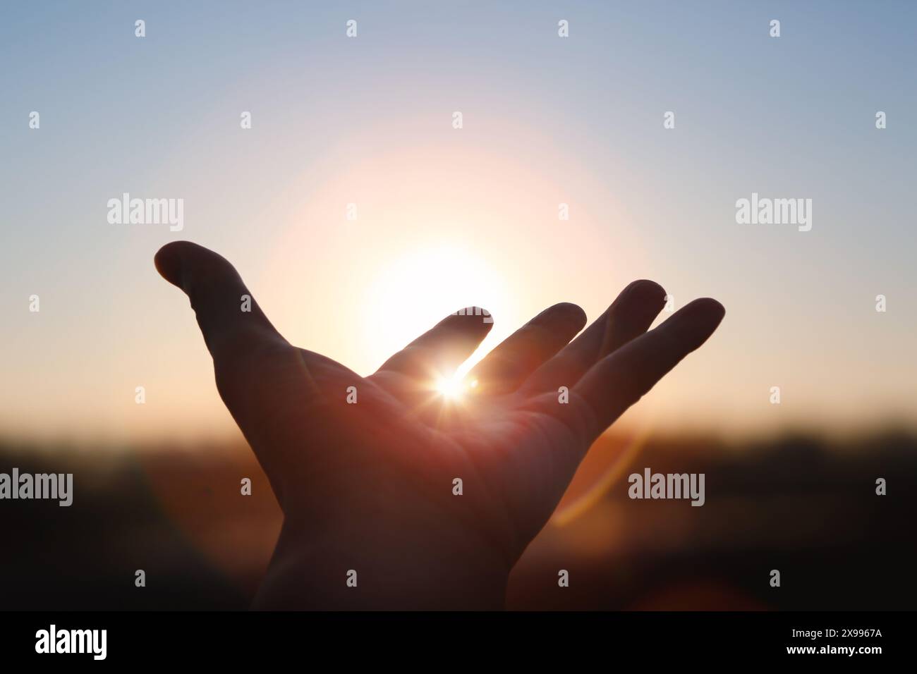 Hands stretched out toward the rising sun at New Year's sunrise ...