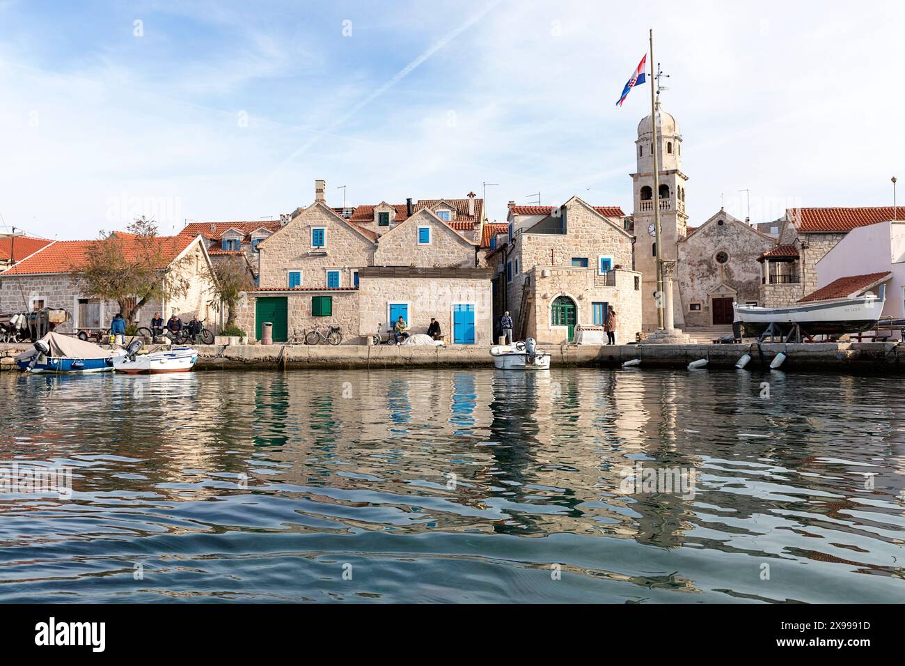Locals sitting on benches in beautiful old part of a village Prvic ...