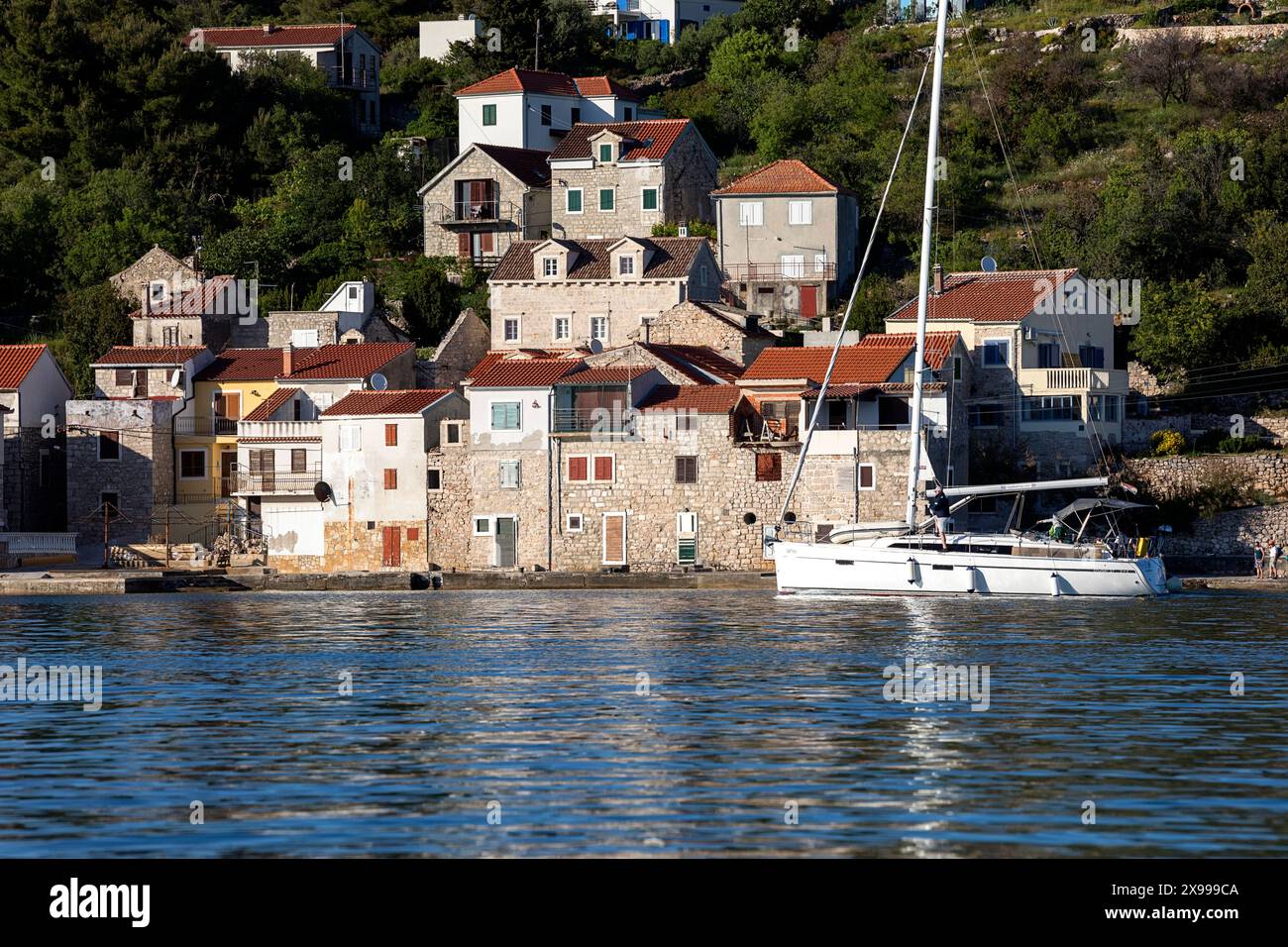 Sailboat infront old traditional stone houses near the sea in a small ...