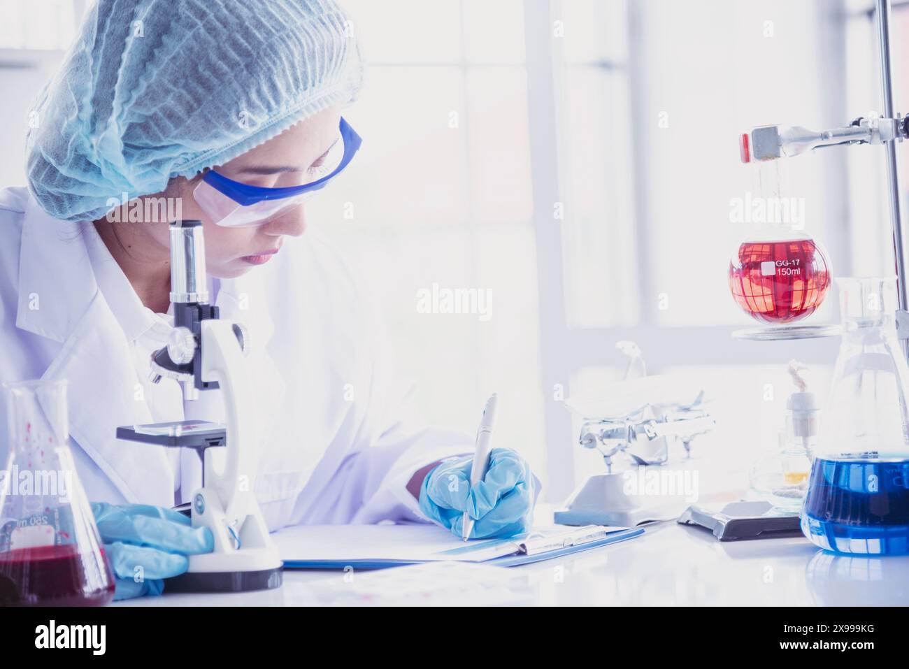 Female scientist look at microscope, science test tube analyse ...