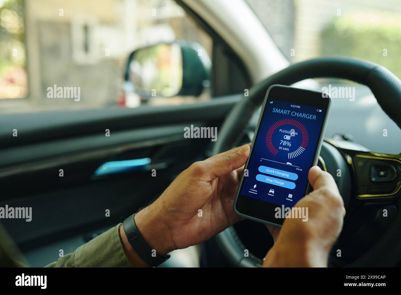 Driver checking charging level via mobile app Stock Photo - Alamy