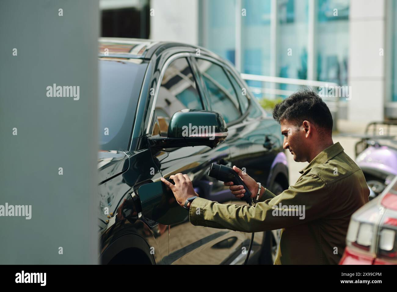 Electric car owner having problem with charging vehicle Stock Photo - Alamy