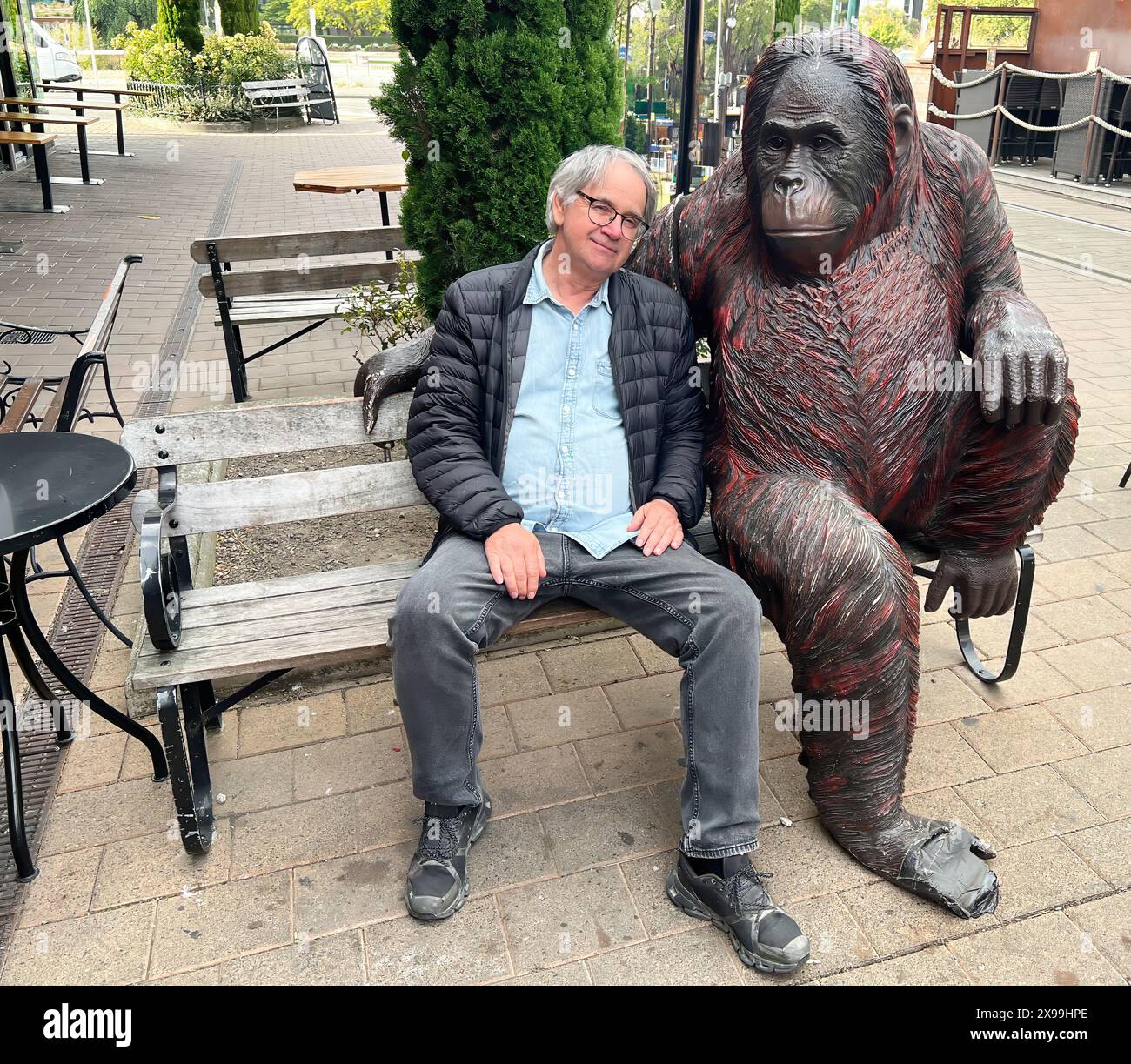Lonely senior tourist having short rest on a park bench leaning against ...