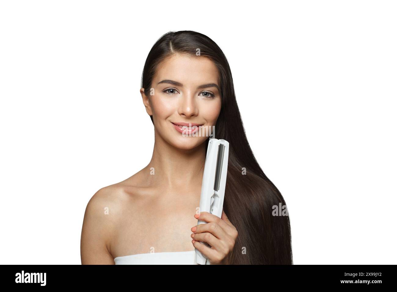 Isolated young healthy brunette woman holding hair iron and ...
