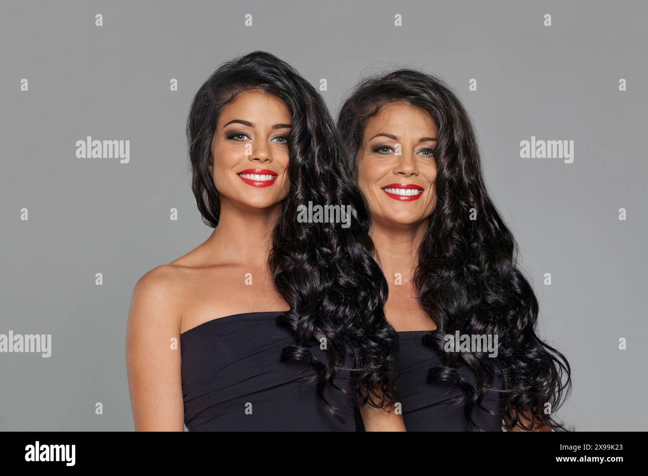 Cheerful models. Young and old woman on white background. Aging ...