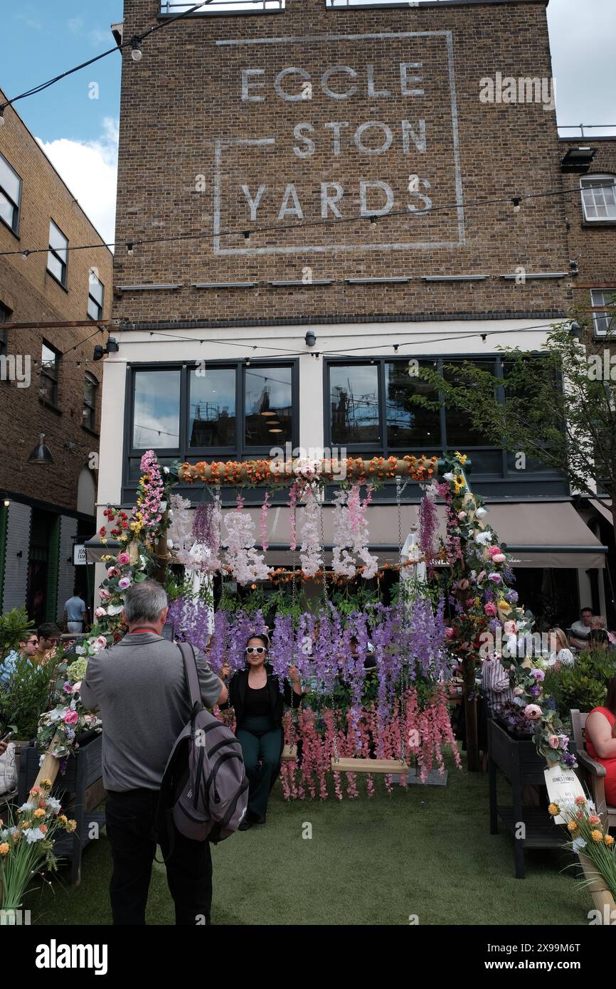 Tourist poses in front of floral display in Eccleston Yards during the ...