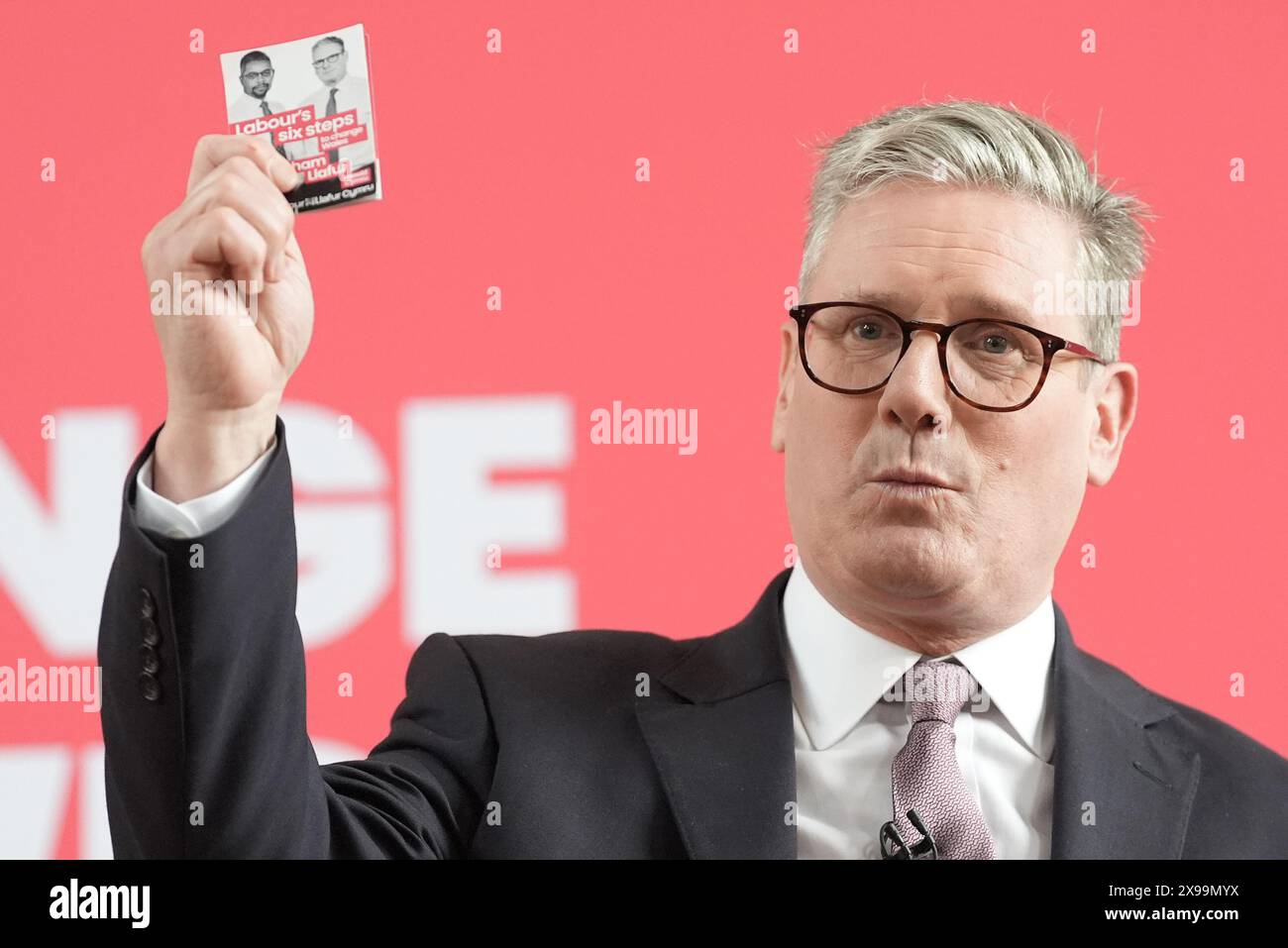 Sir Keir Starmer holds a Labour pledge card while speaking at the ...