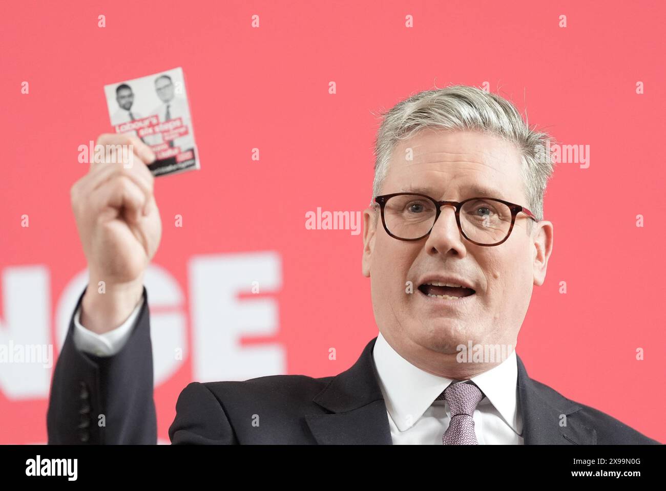 Sir Keir Starmer holds a Labour pledge card while speaking at the ...