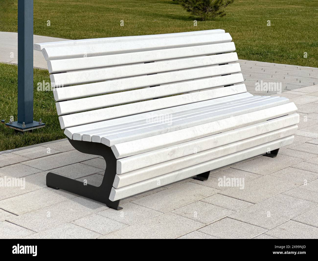 Modern wooden benches standing on the sides of the paved paths of the ...