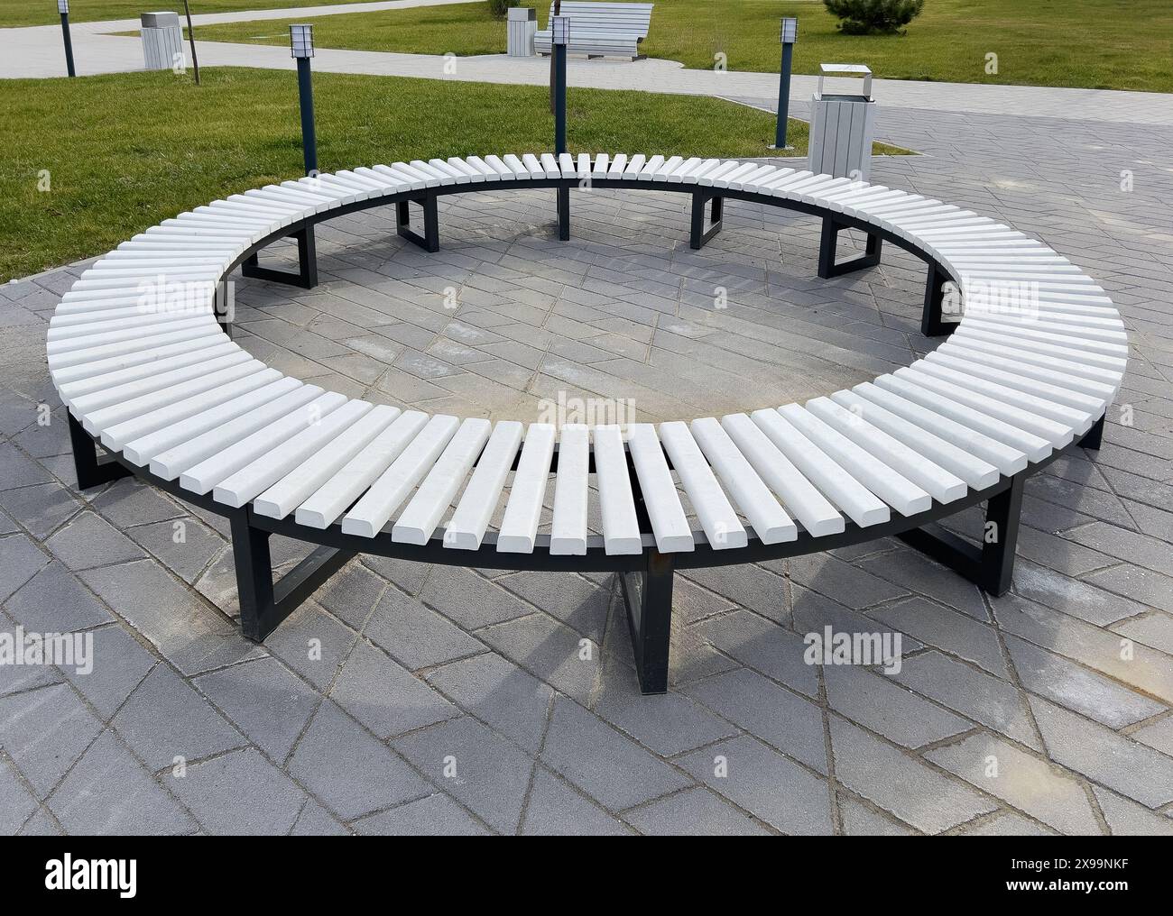 Modern wooden bench standing on the sides of the paved paths of the ...