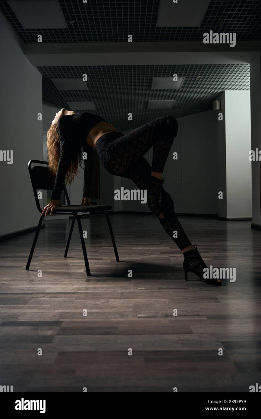 Flexible female performing stiletto dance in studio using prop Stock ...