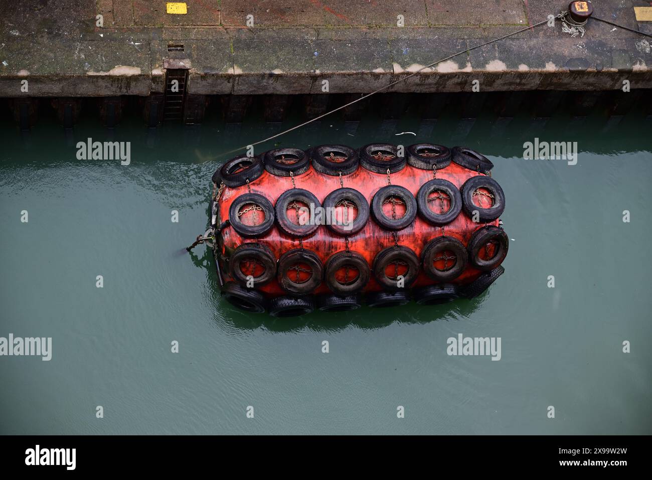 A marine fender beside the harbour wall at the Queen Elizabeth II ...