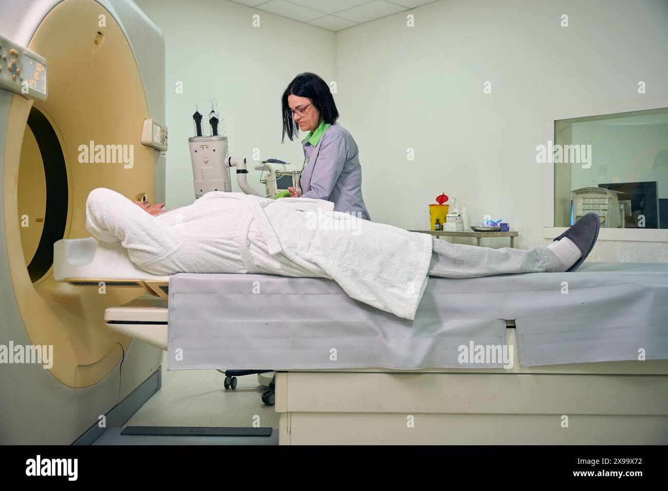 Lady doctor helping patient to get into MRI machine Stock Photo - Alamy