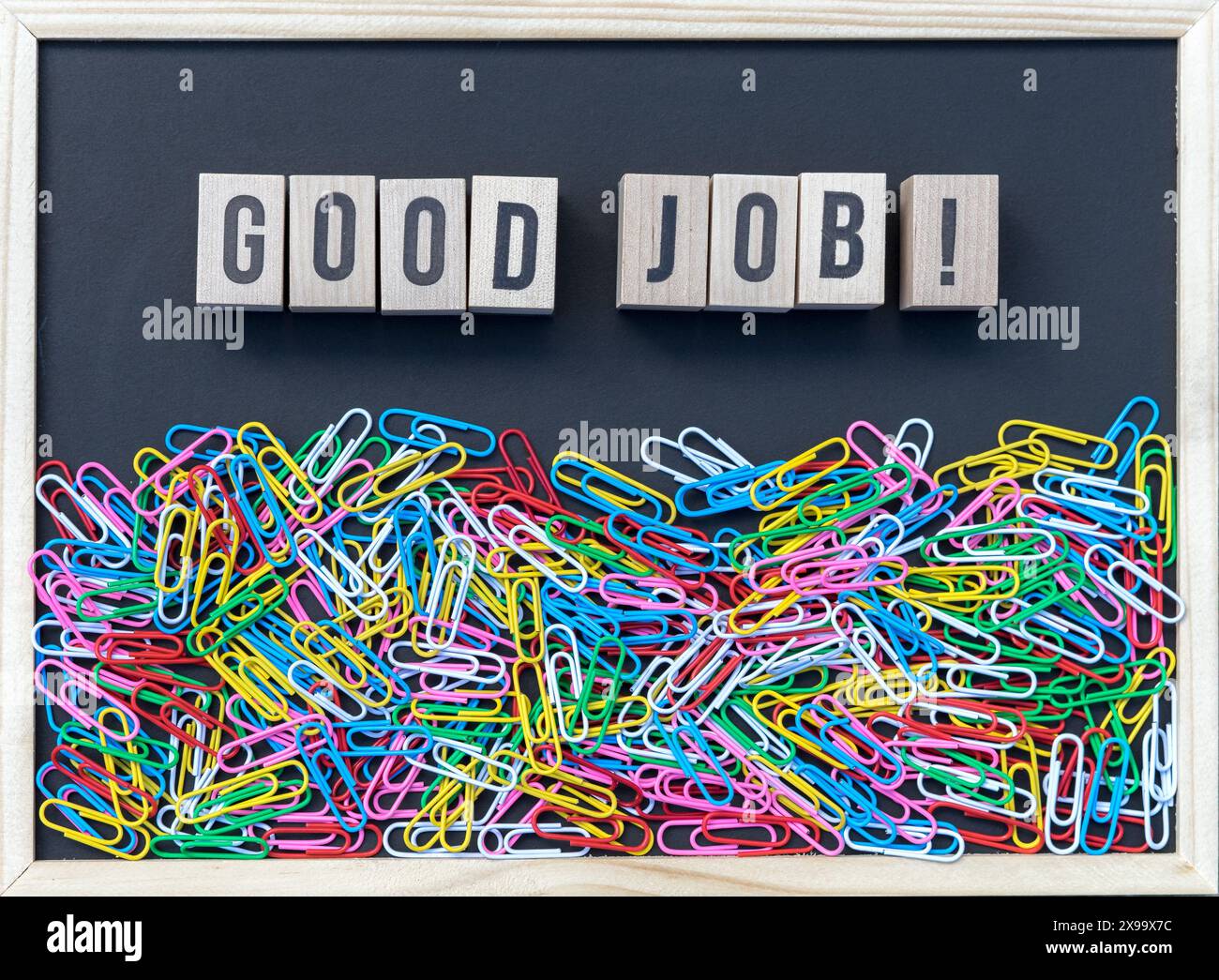 Black board with colorful paper clips and wooden cubes with the text ...