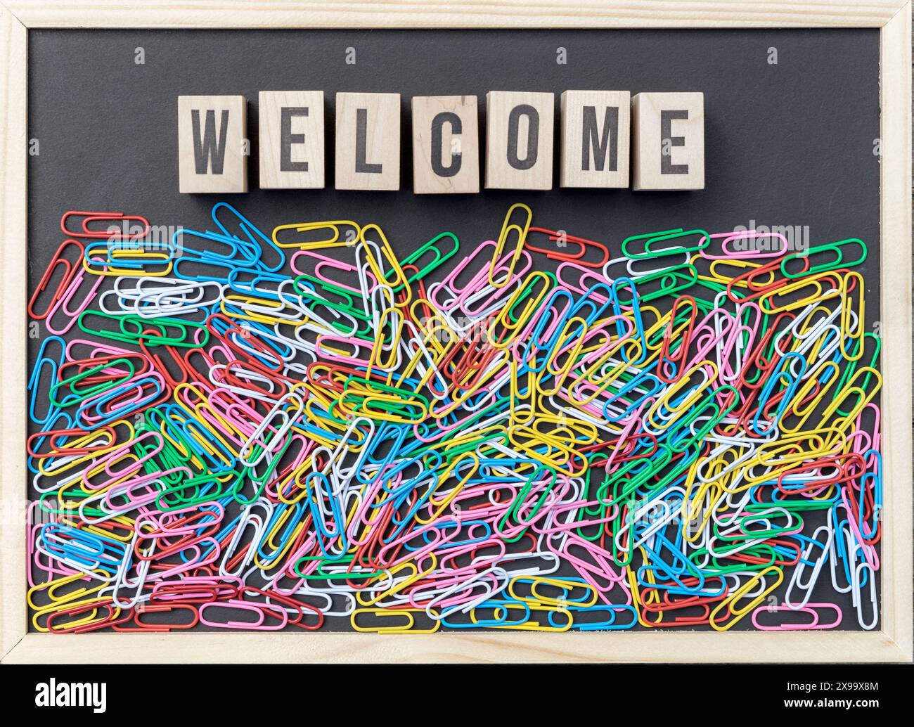 Black board with colorful paper clips and wooden cubes with the text ...