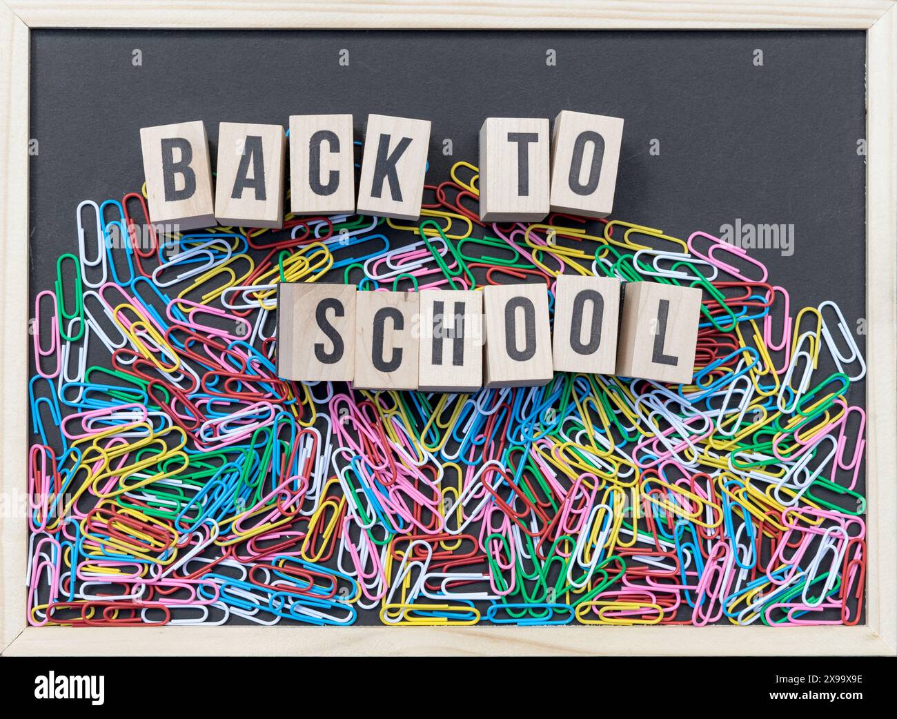 Black board with colorful paper clips and wooden cubes with the text ...