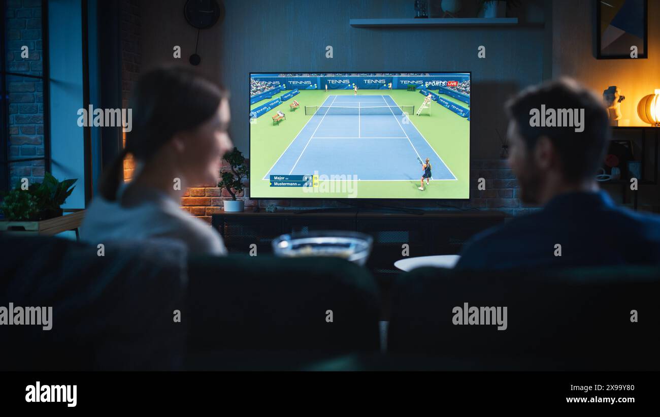 Authentic Couple Spending Time at Home, Sitting on a Couch and Watching ...