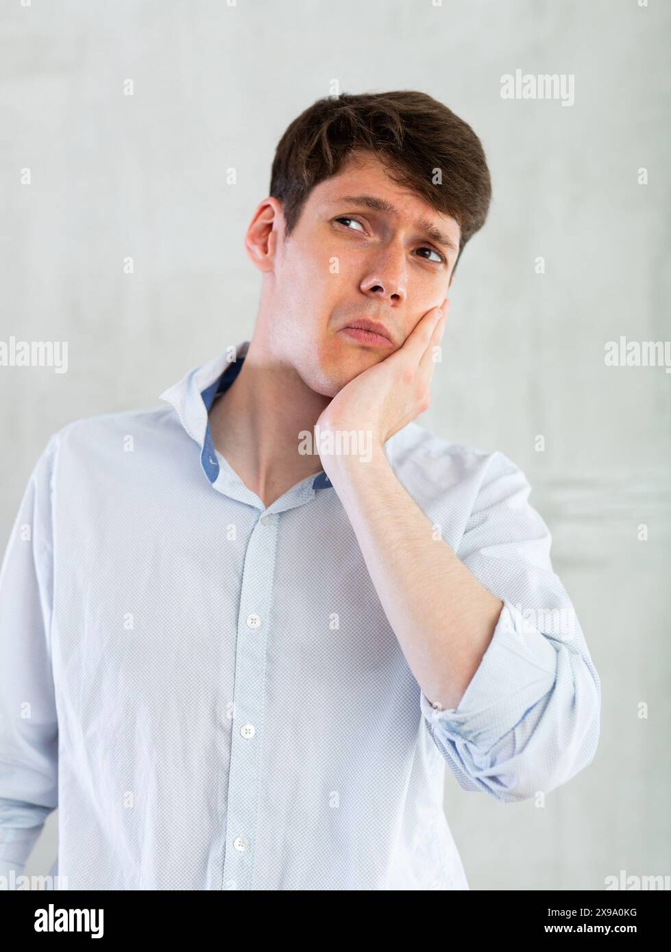Young guy holding his cheek with toothache Stock Photo - Alamy