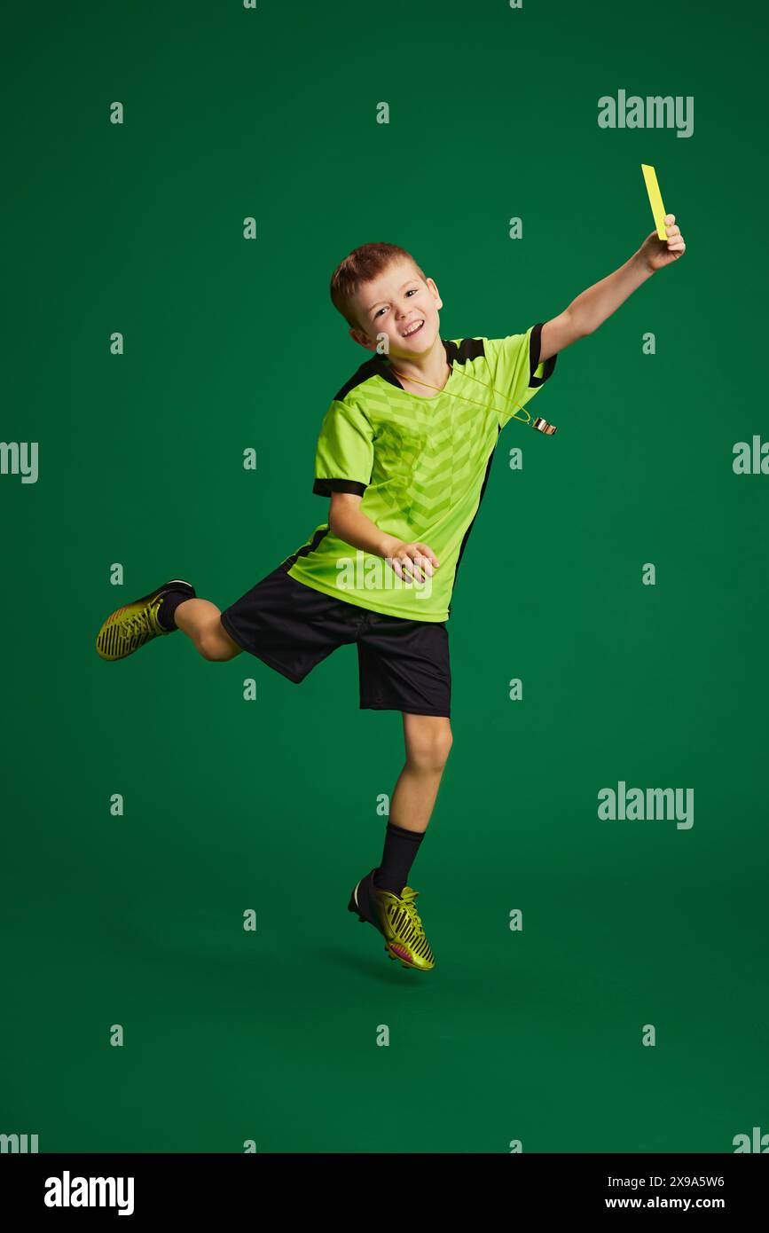 Little boy, kid referee showing yellow card and joyfully jumping ...